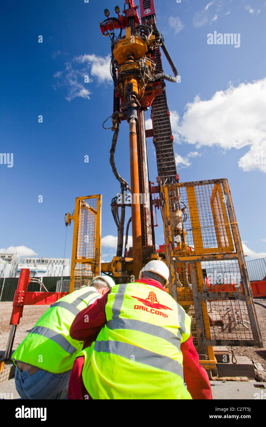 A workman measures the depth of the borehole at a geothermal energy ...