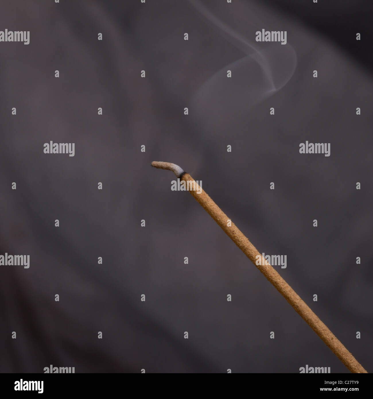 Incense joss stick Burning with smoke trail against dark background ...