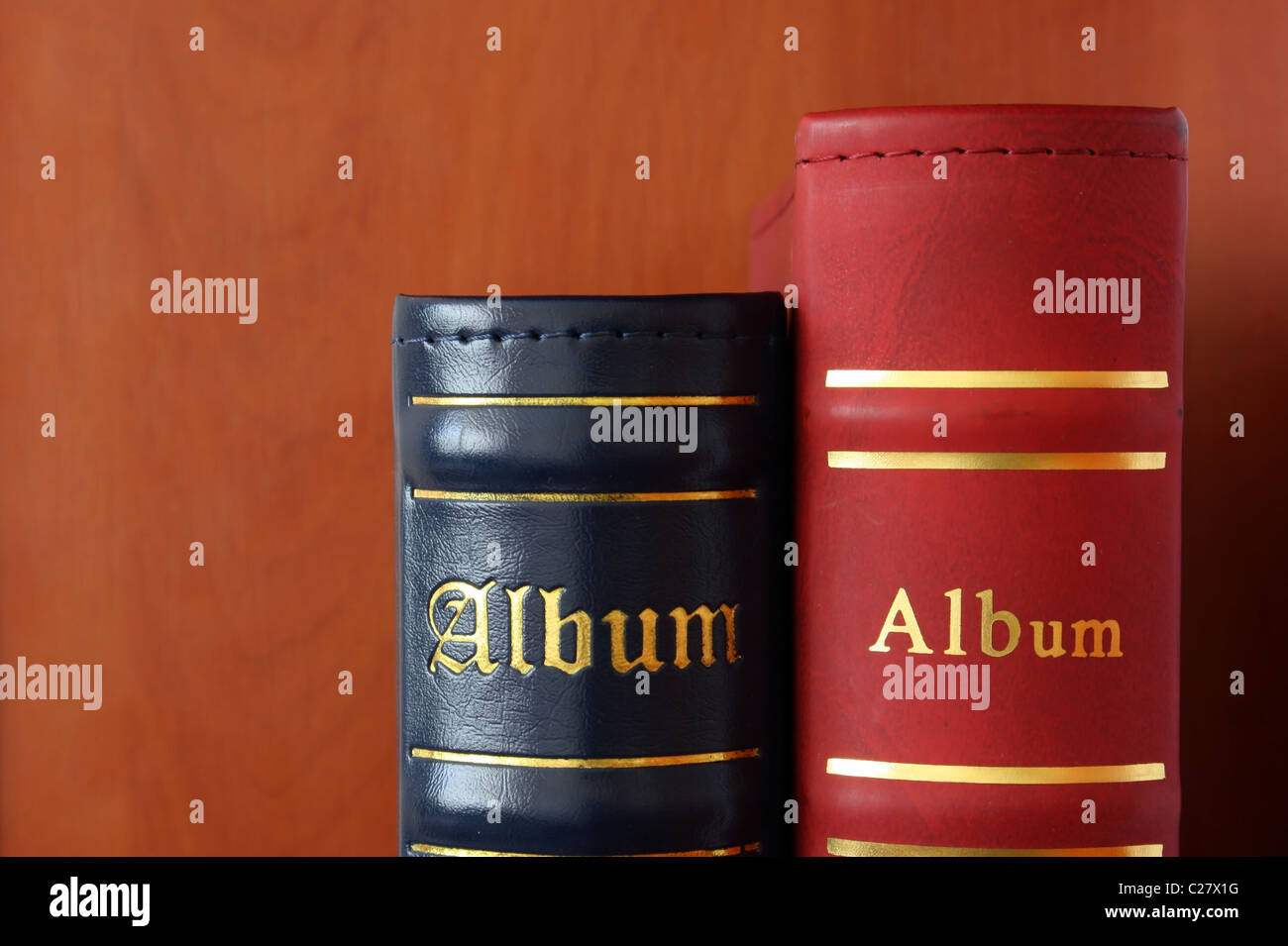The top part of picture albums of dark blue and red color on a brown ...