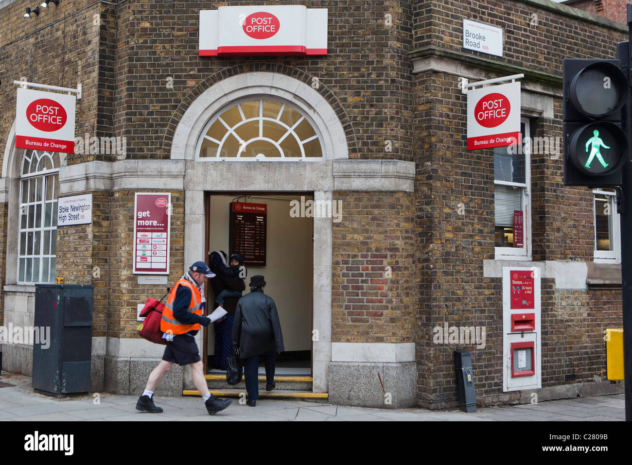 A post man walking past the Post office branch in Stoke Newington ...