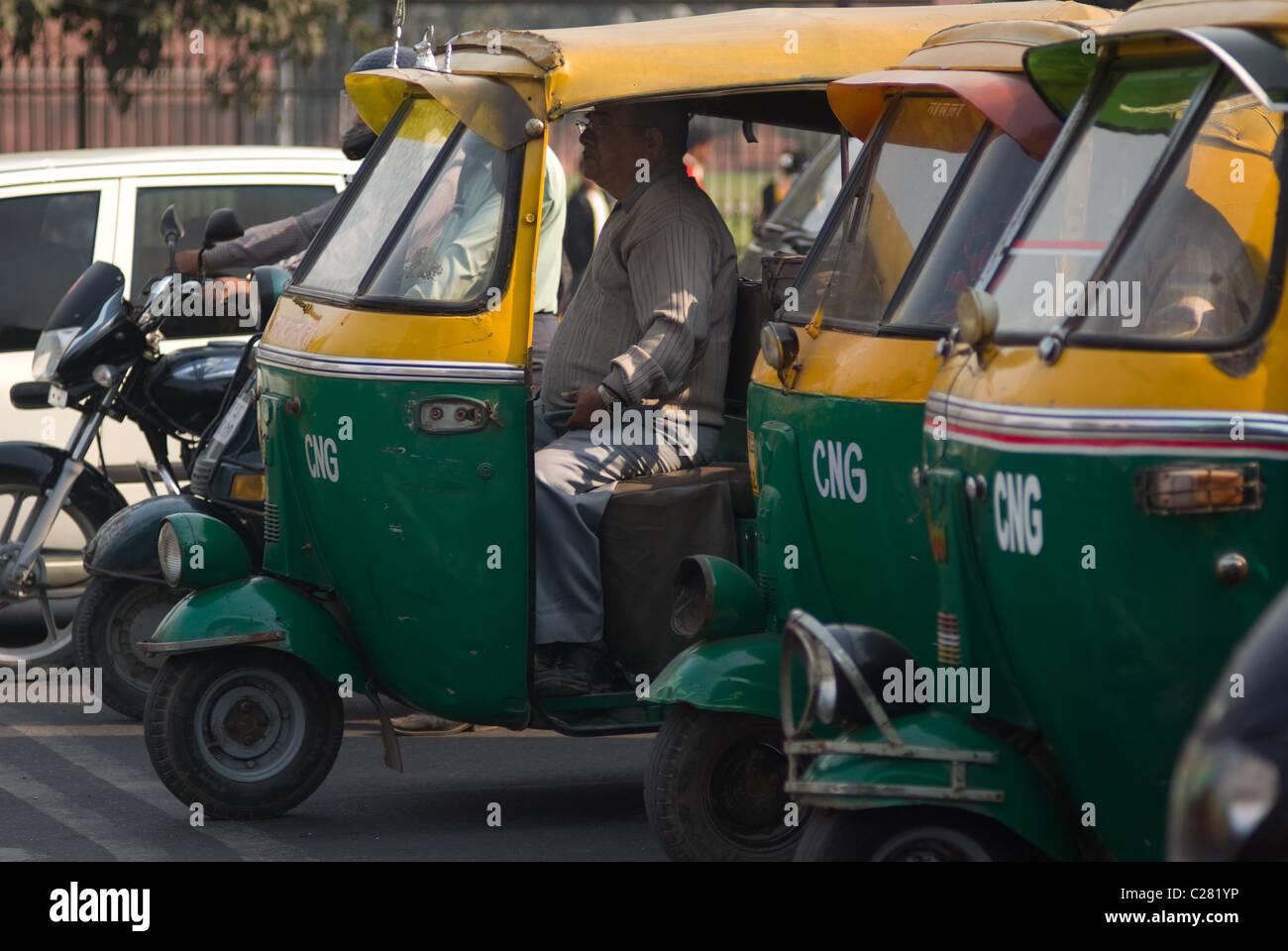 Green-and-yellow auto rickshaws on a street in Delhi Stock Photo - Alamy