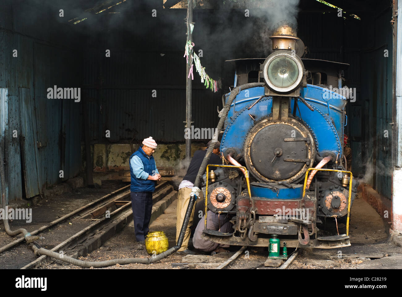 Engineers doing a service of a narrow-gauge old-style steam train ...