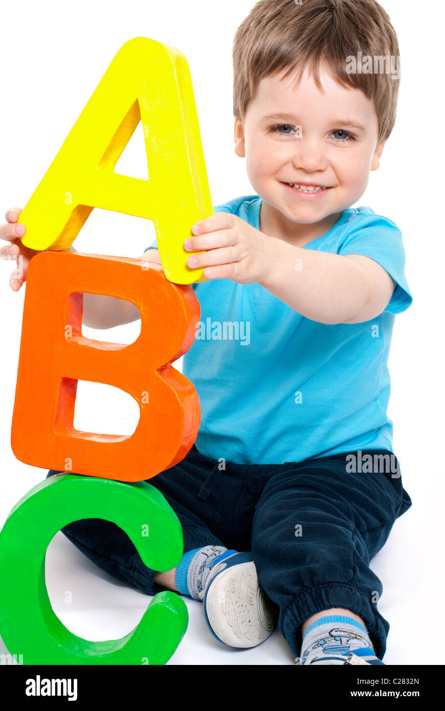 Happy boy holding letters of the alphabet Stock Photo - Alamy