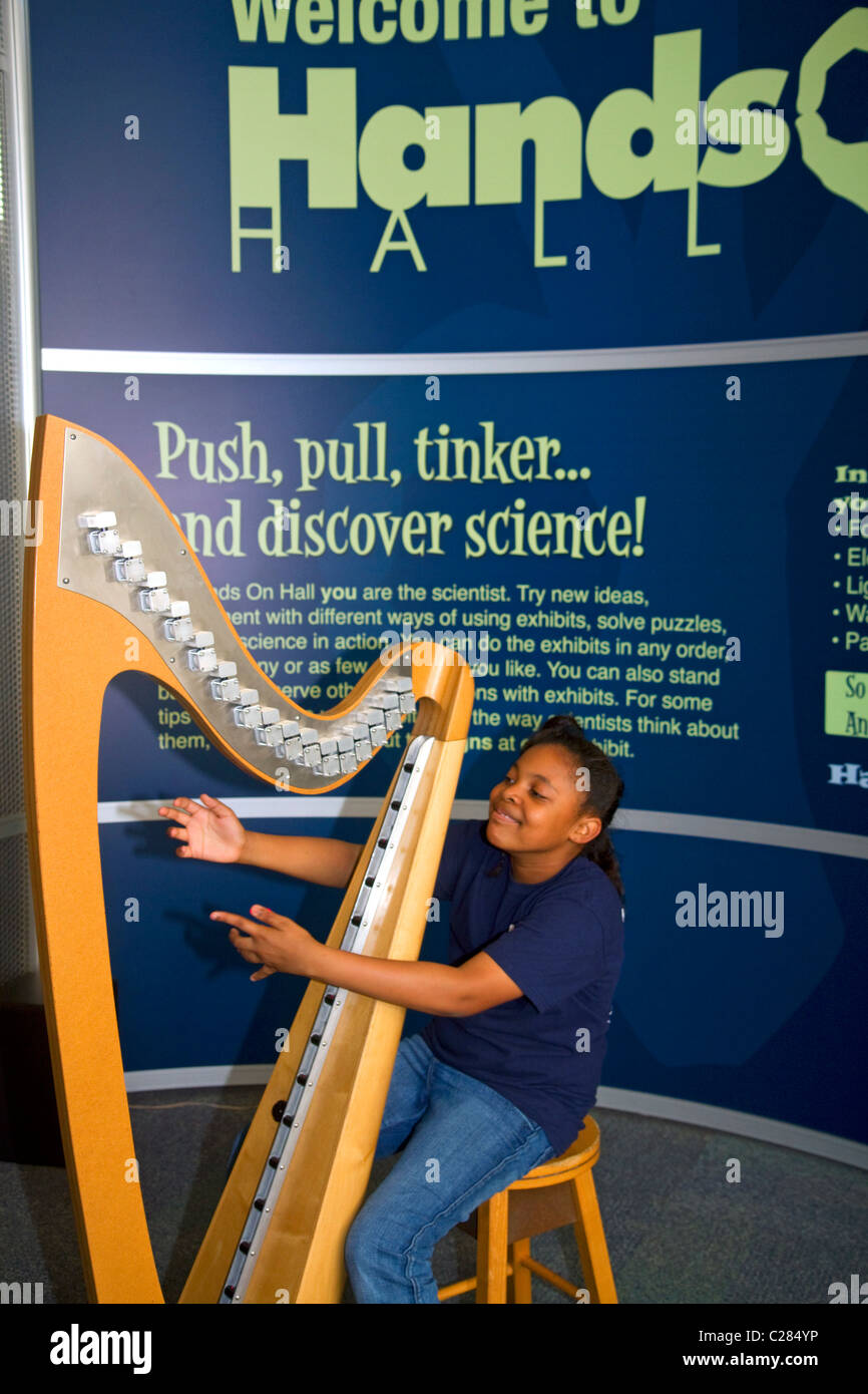 Child playing an electronic stringless harp at the Gulf Coast Exploreum ...