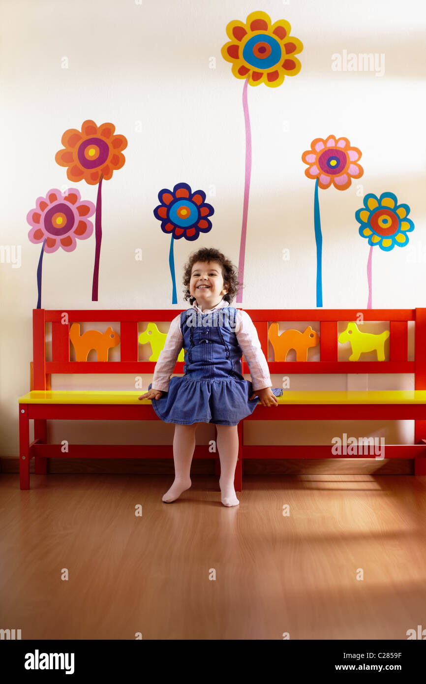 hispanic female preschooler sitting on bench in kindergarten and ...
