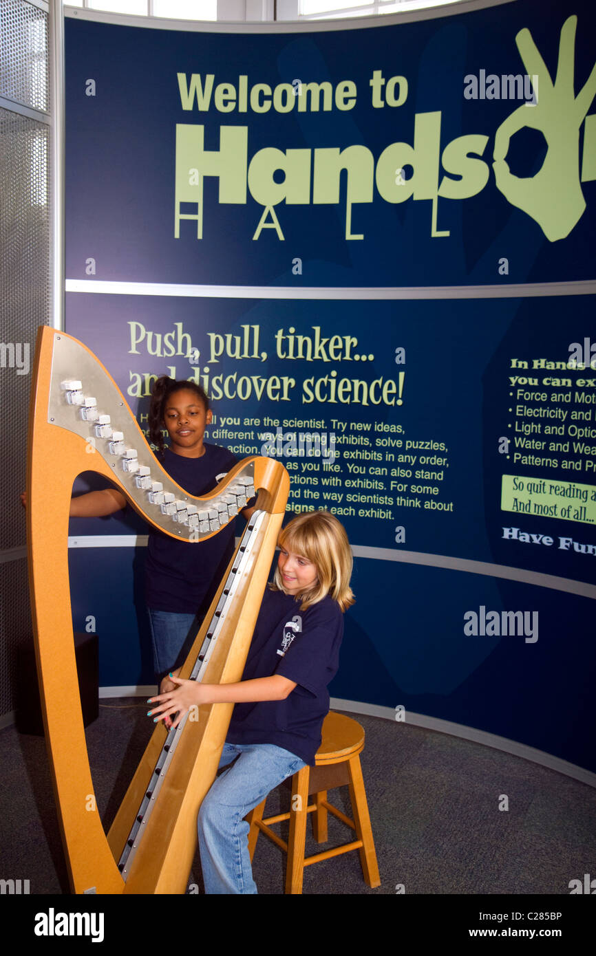 Child playing an electronic stringless harp at the Gulf Coast Exploreum ...