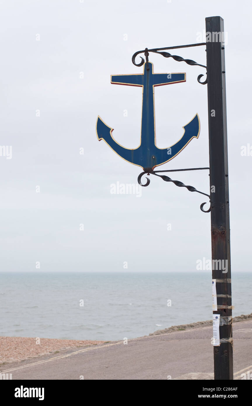 The anchor sign for The Anchor Inn with the English Channel in the ...