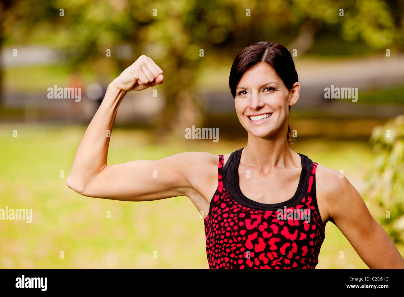 A pretty fitness model flexing her bicep Stock Photo - Alamy