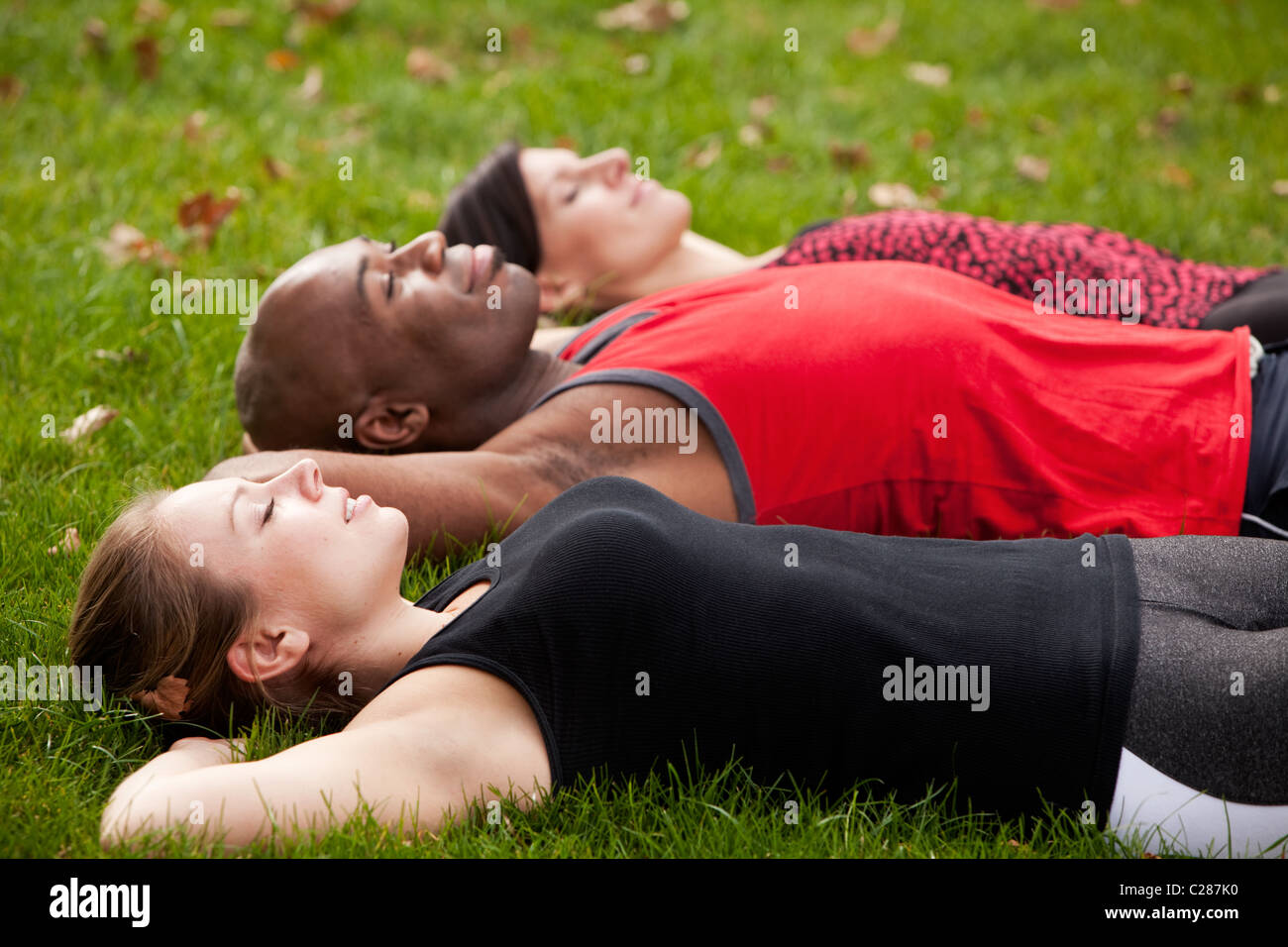 A group of people relaxing in a park after exercise Stock Photo - Alamy