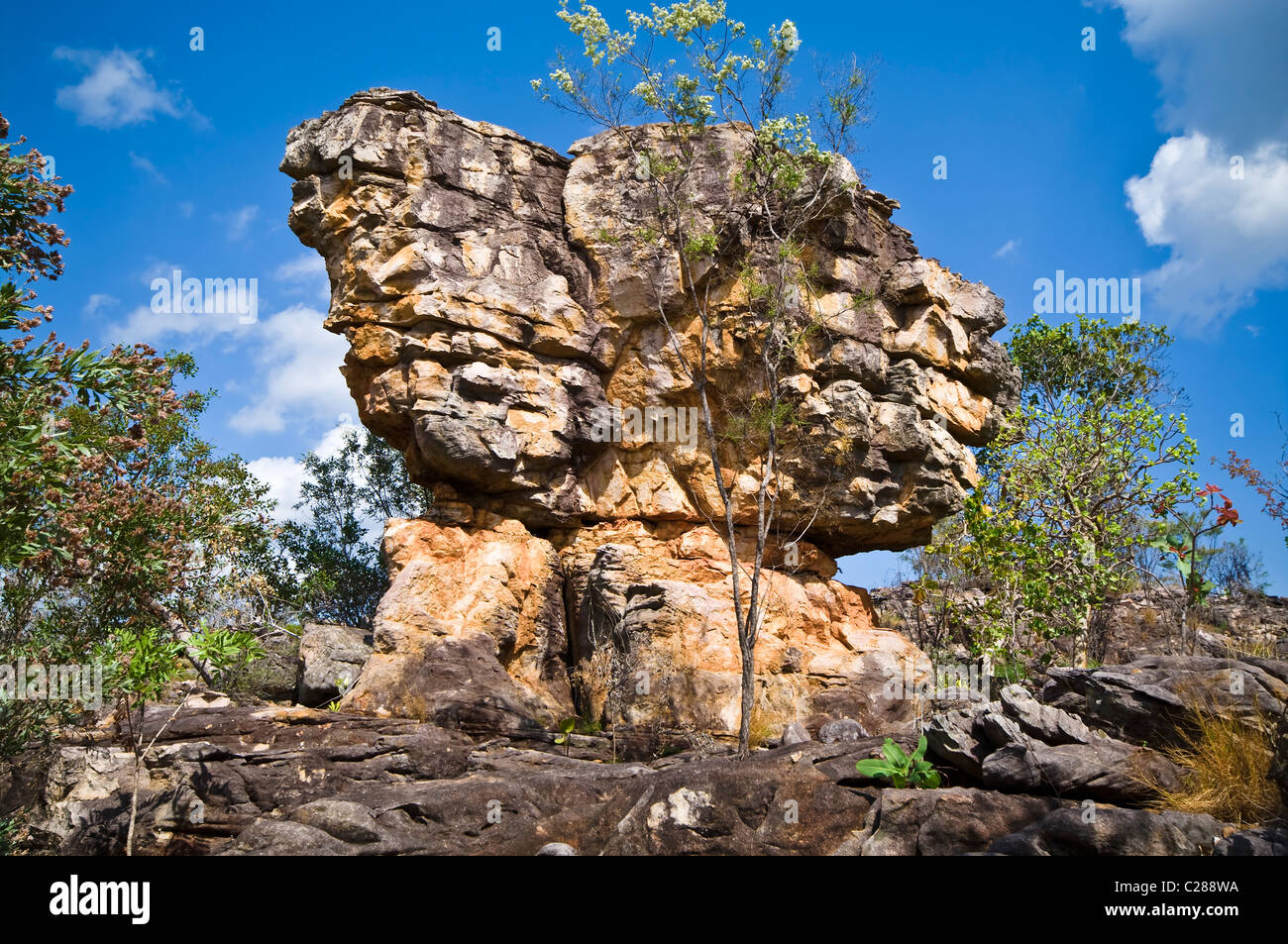 A weathered and rugged boulder outcrop rises from a sandstone plateau ...