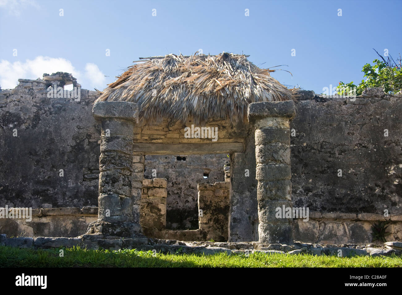 Stone ruins with palm tree thatched roof across from Templo del los ...