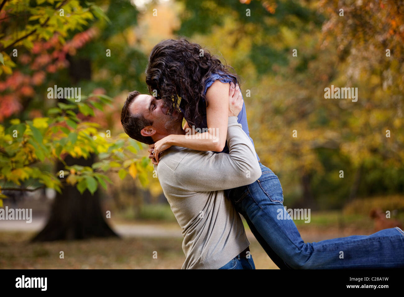 A man giving a woman a big hug in a park Stock Photo - Alamy
