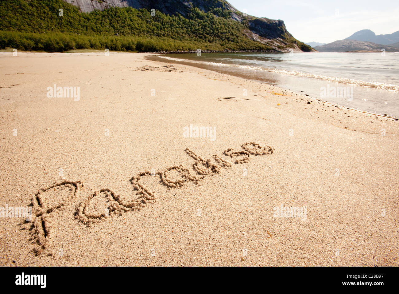 The word paradise written in the sand on a beautiful island Stock Photo ...