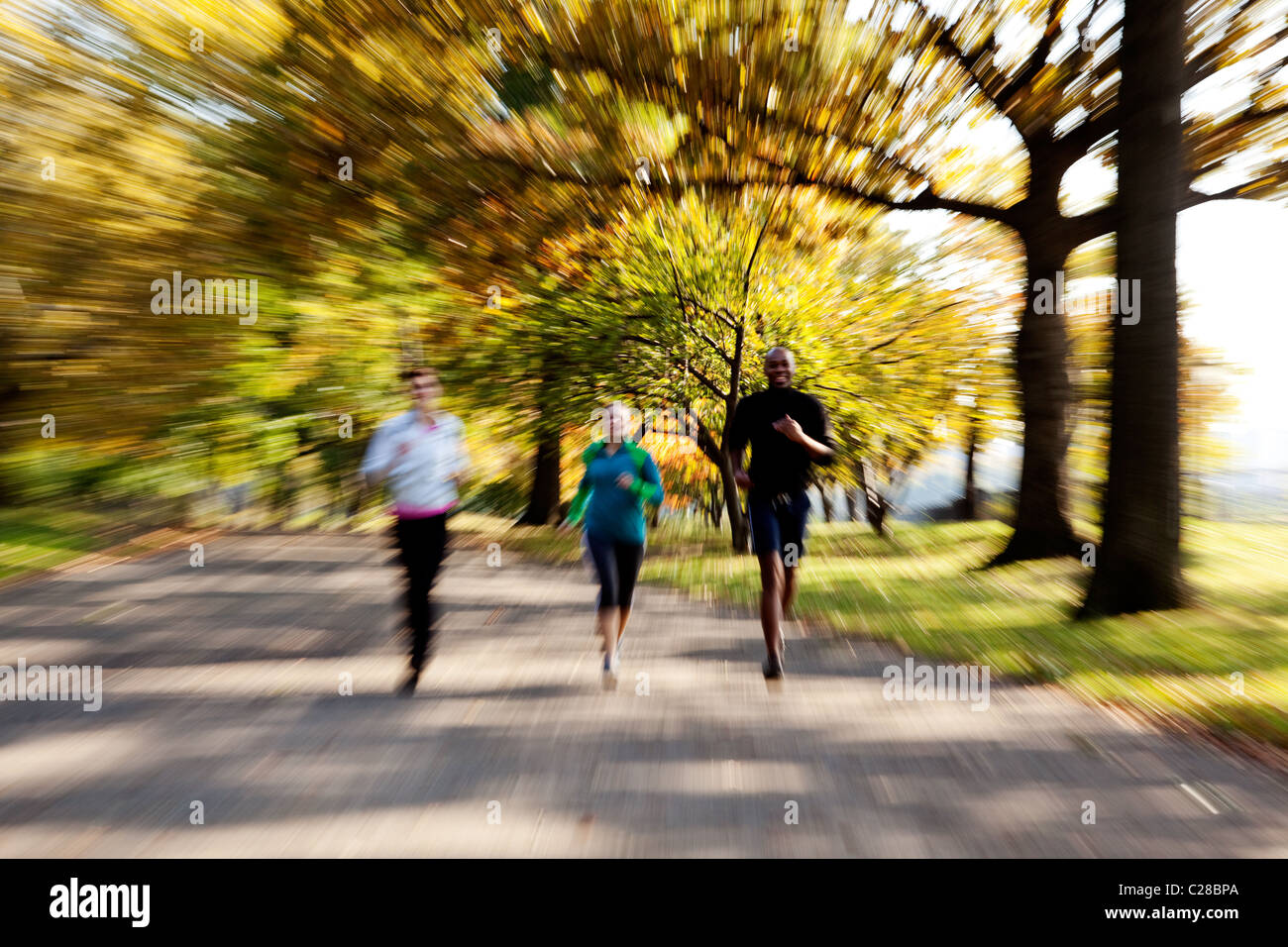 Three people jogging in the park with zoom blur Stock Photo - Alamy