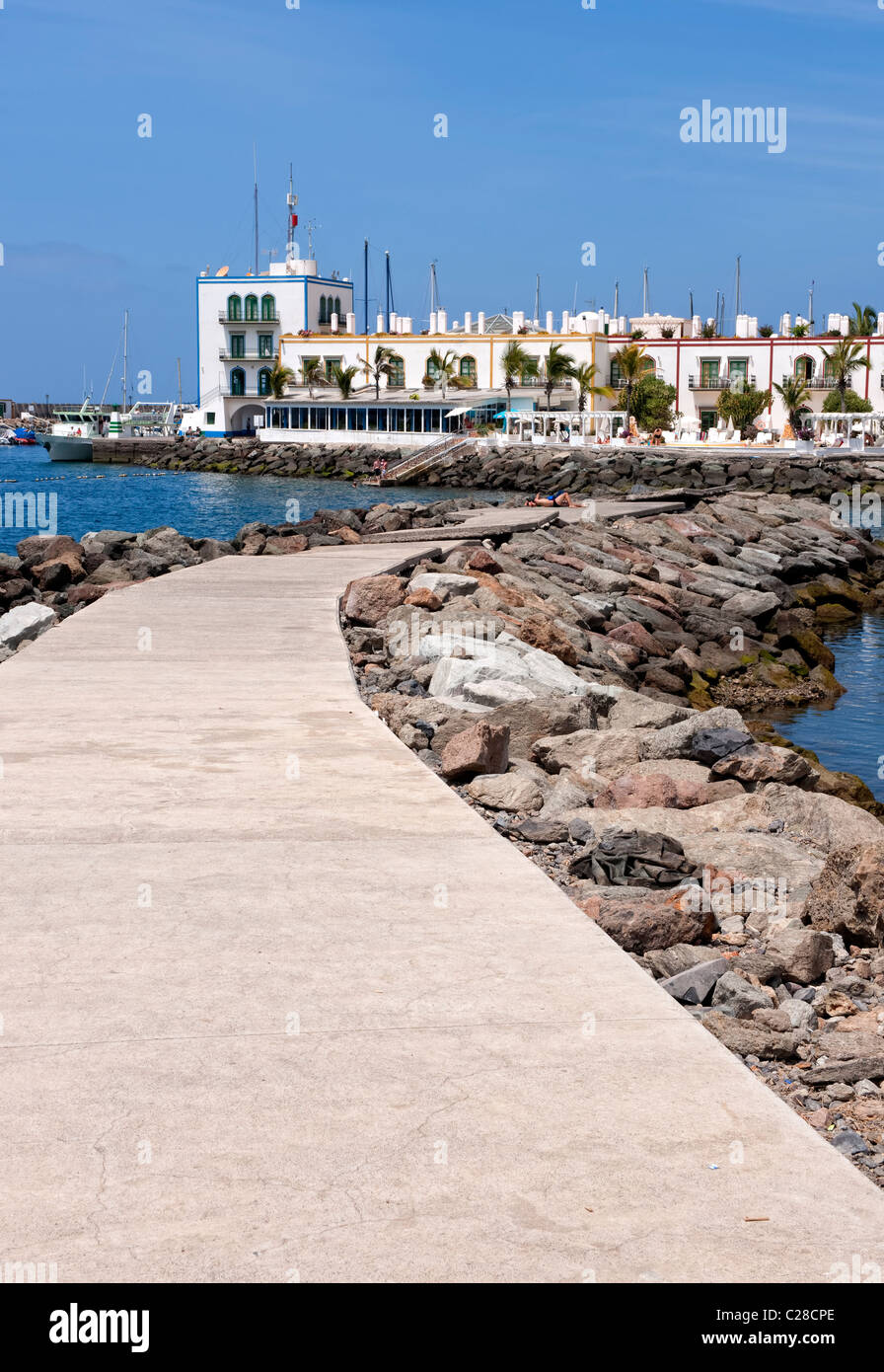 Causeway along the wall of the man made harbour at Puerto Mogan in Gran ...
