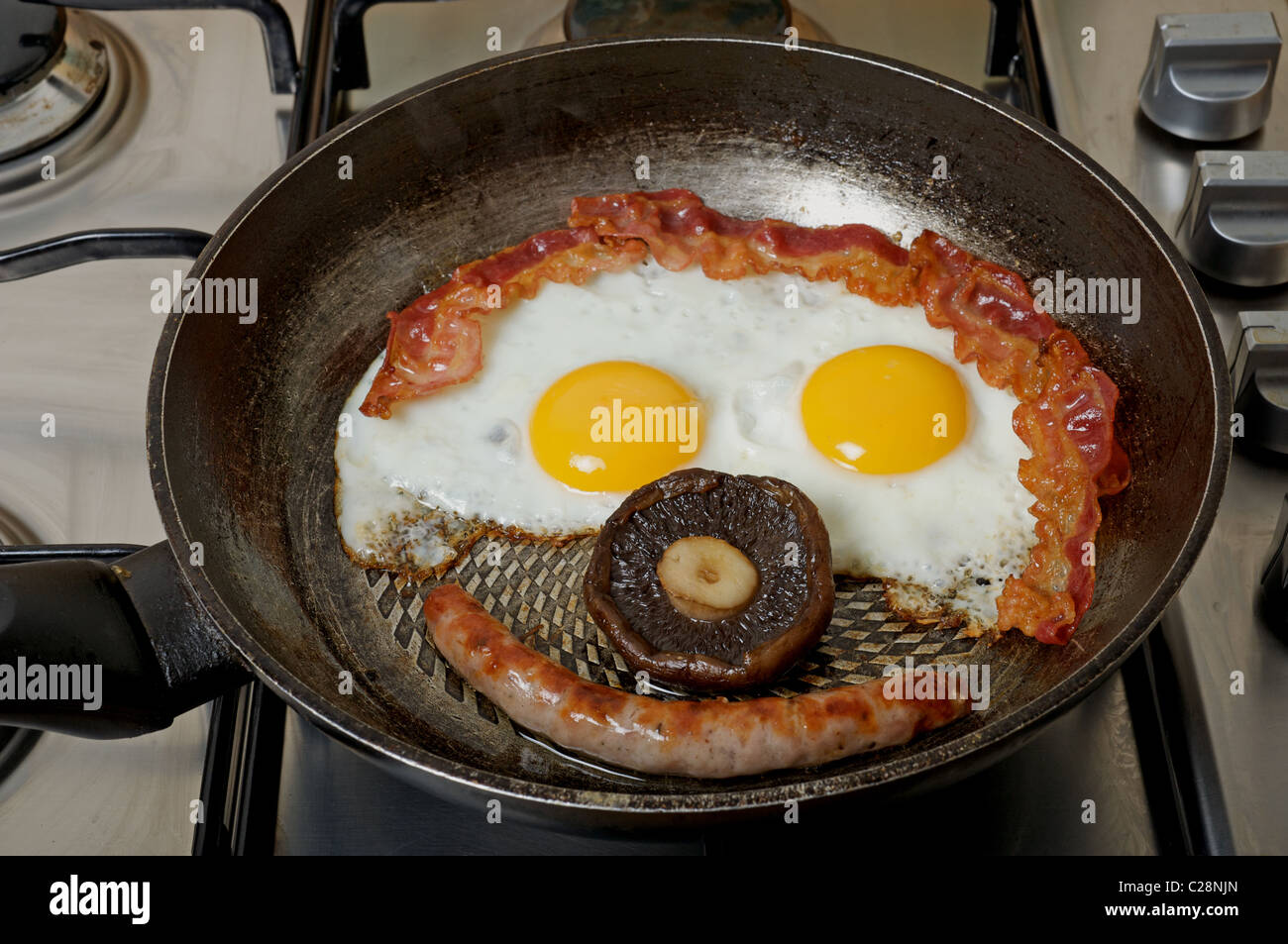Fried breakfast cooking in pan in the shape of a human face Stock Photo ...
