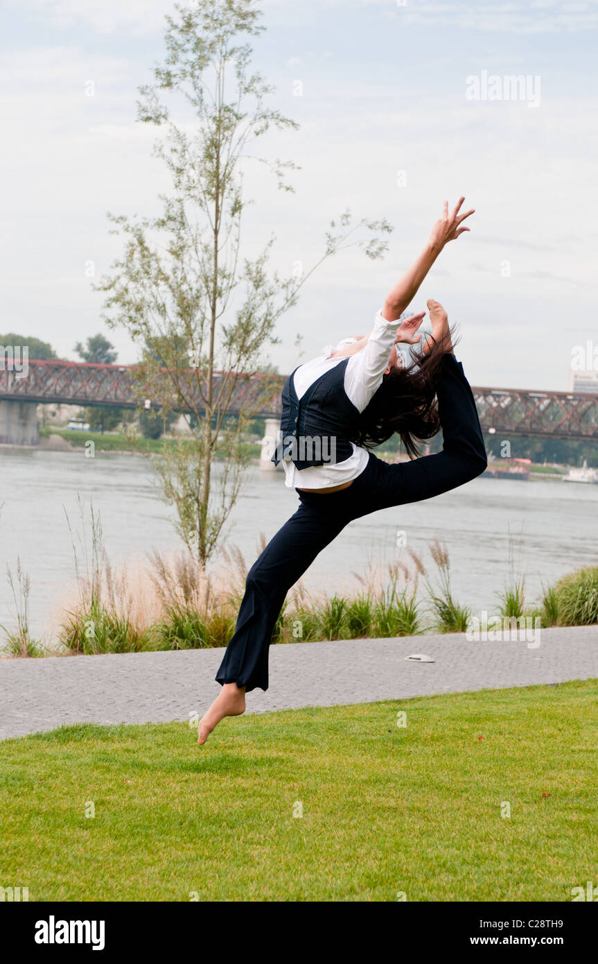 Woman in gymnastics jump outdoors Stock Photo - Alamy