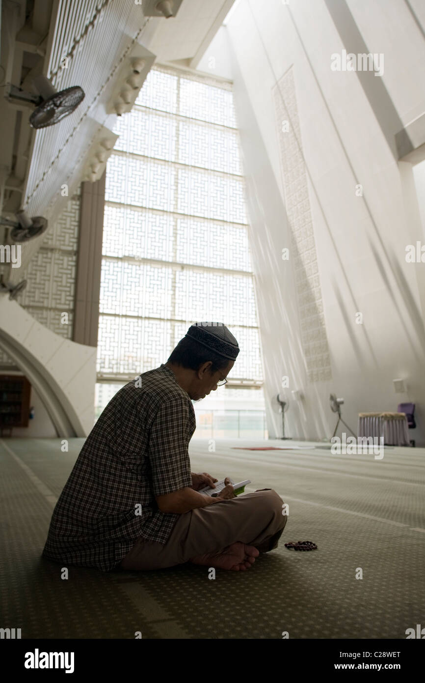 A man reads a prayer book in the main prayer hall at the Assyafaah ...