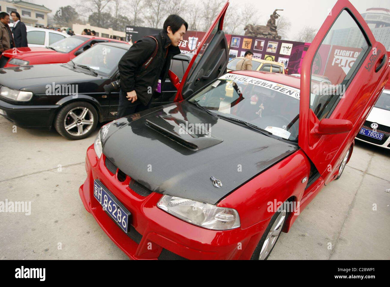 Petrol-heads admire a display of modified cars in Beijing, China ...