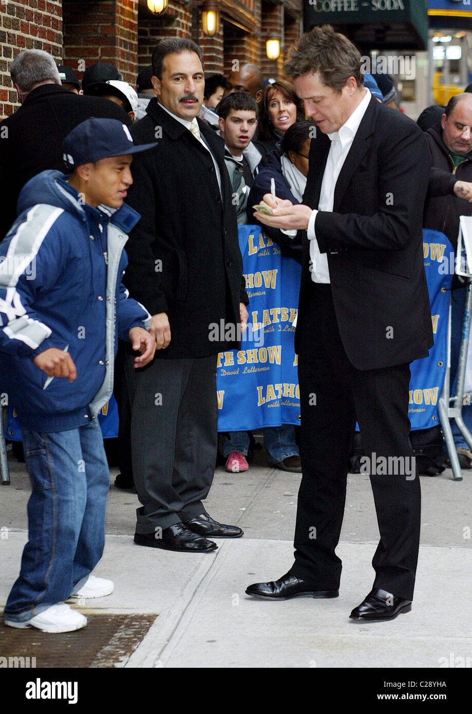 Hugh Grant signs an autograph for a young boy outside the Ed Sullivan ...