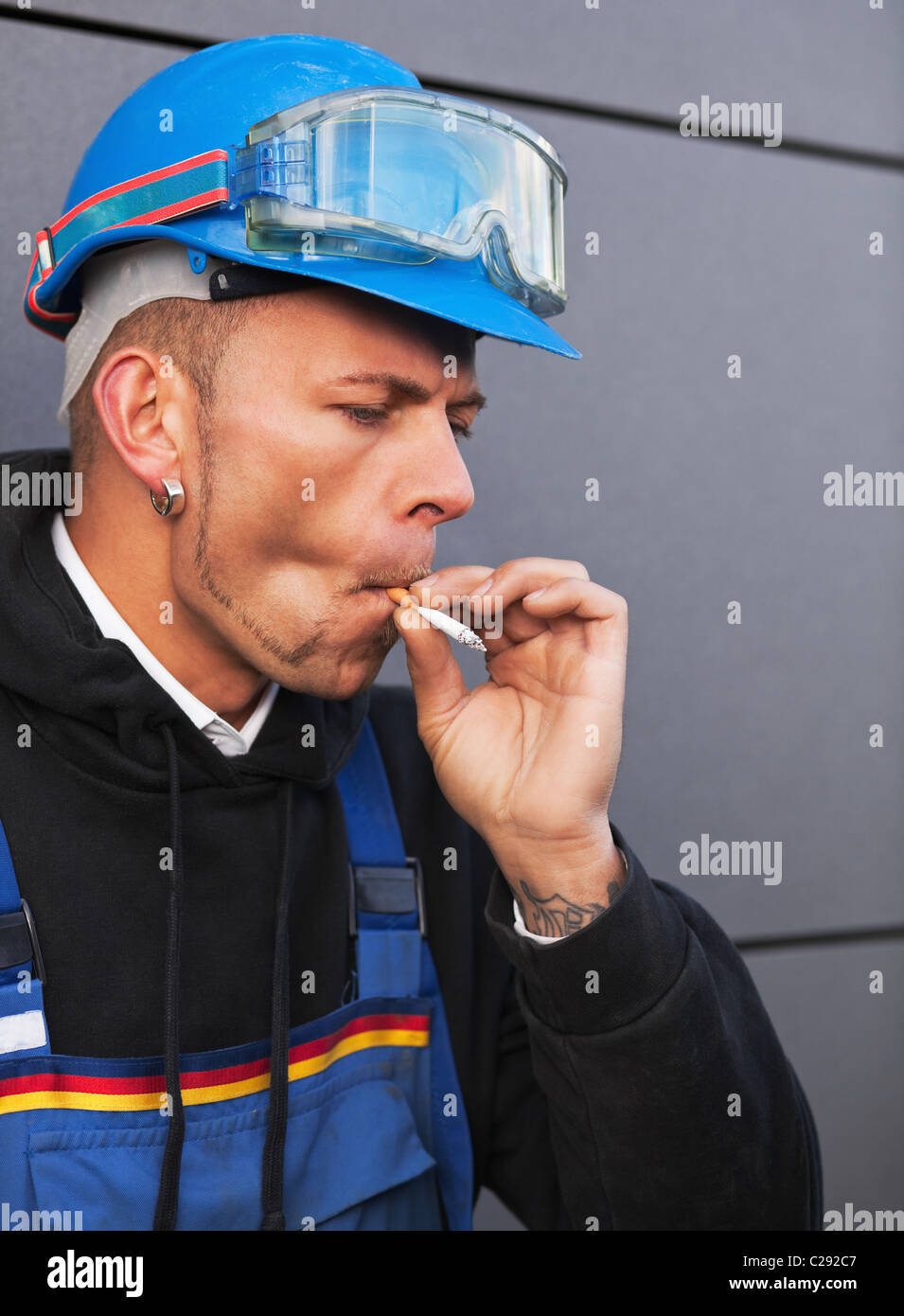Portrait of an unhappy manual worker smoking a cigarette Stock Photo ...