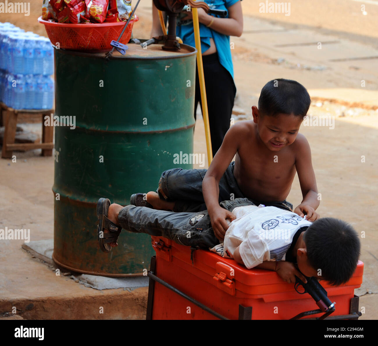 Two young boys playing on the pavement in Sen Monorom town. Cambodia ...