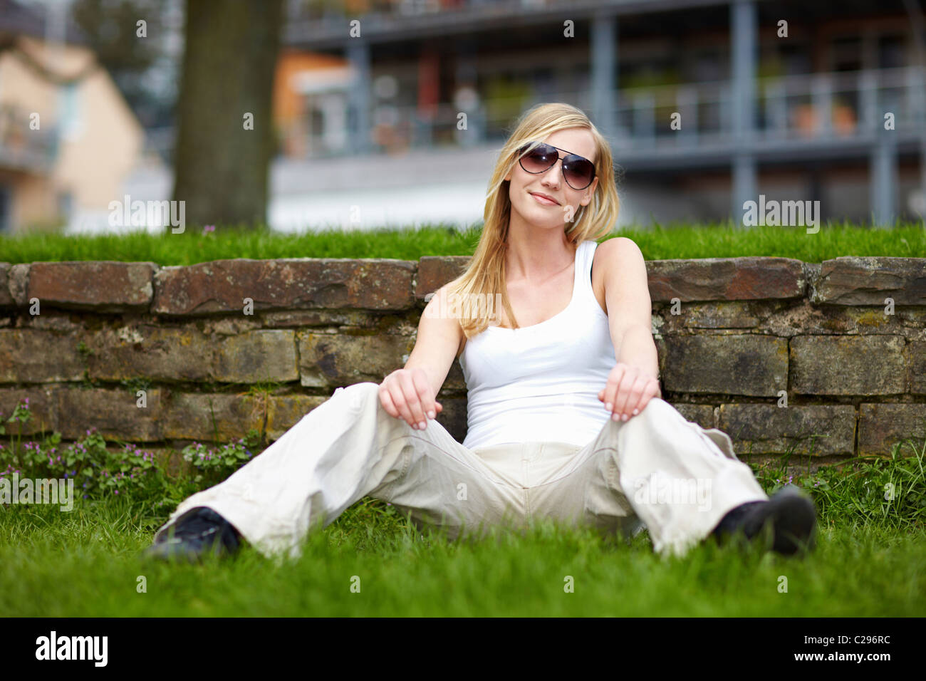 Woman sitting in grass Stock Photo - Alamy