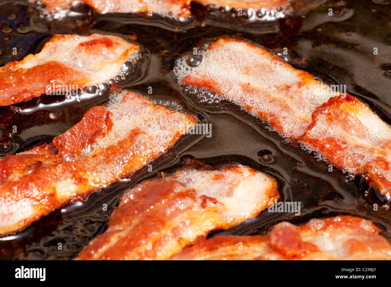 A bacon cooking detail, slices of bacon in fat Stock Photo - Alamy