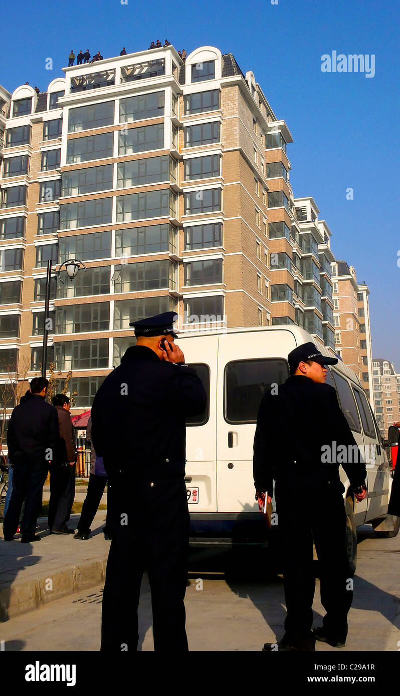 A group of rural migrant construction workers stand in protest on the ...