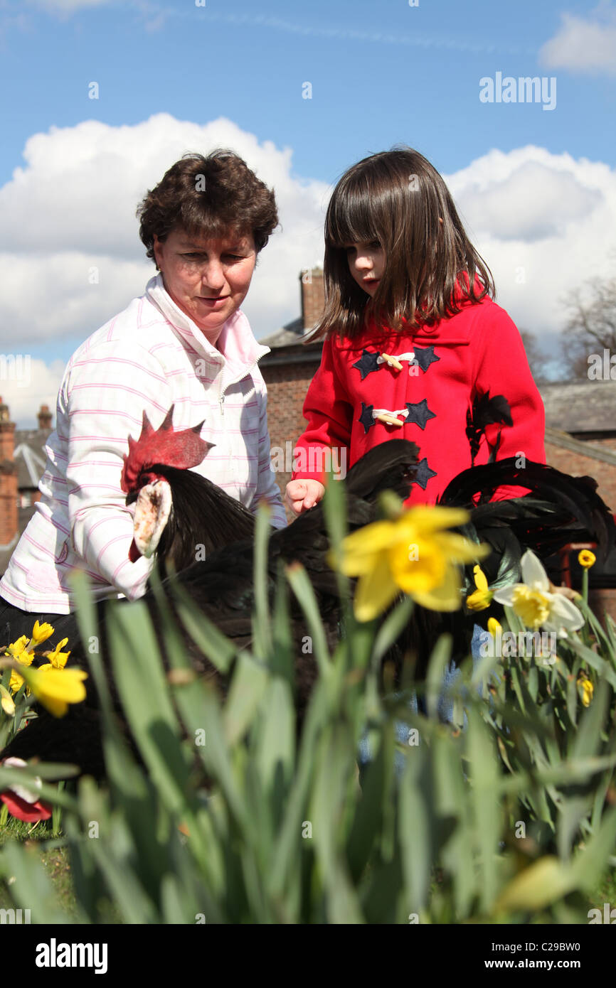 Estate of Tatton Park, England. A pretty young girl in a bright red ...