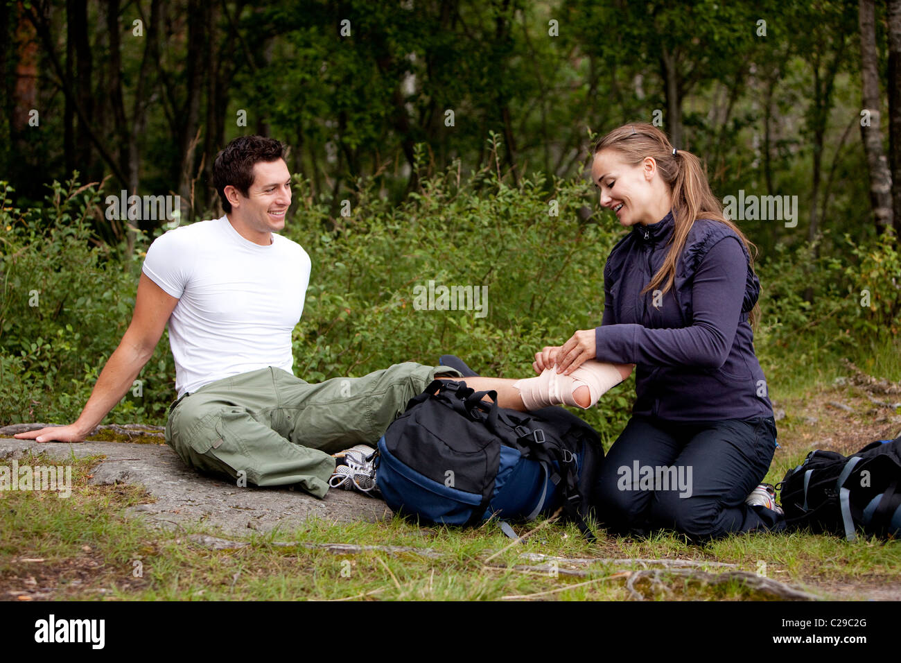 A couple camping and putting on a leg bandage Stock Photo - Alamy