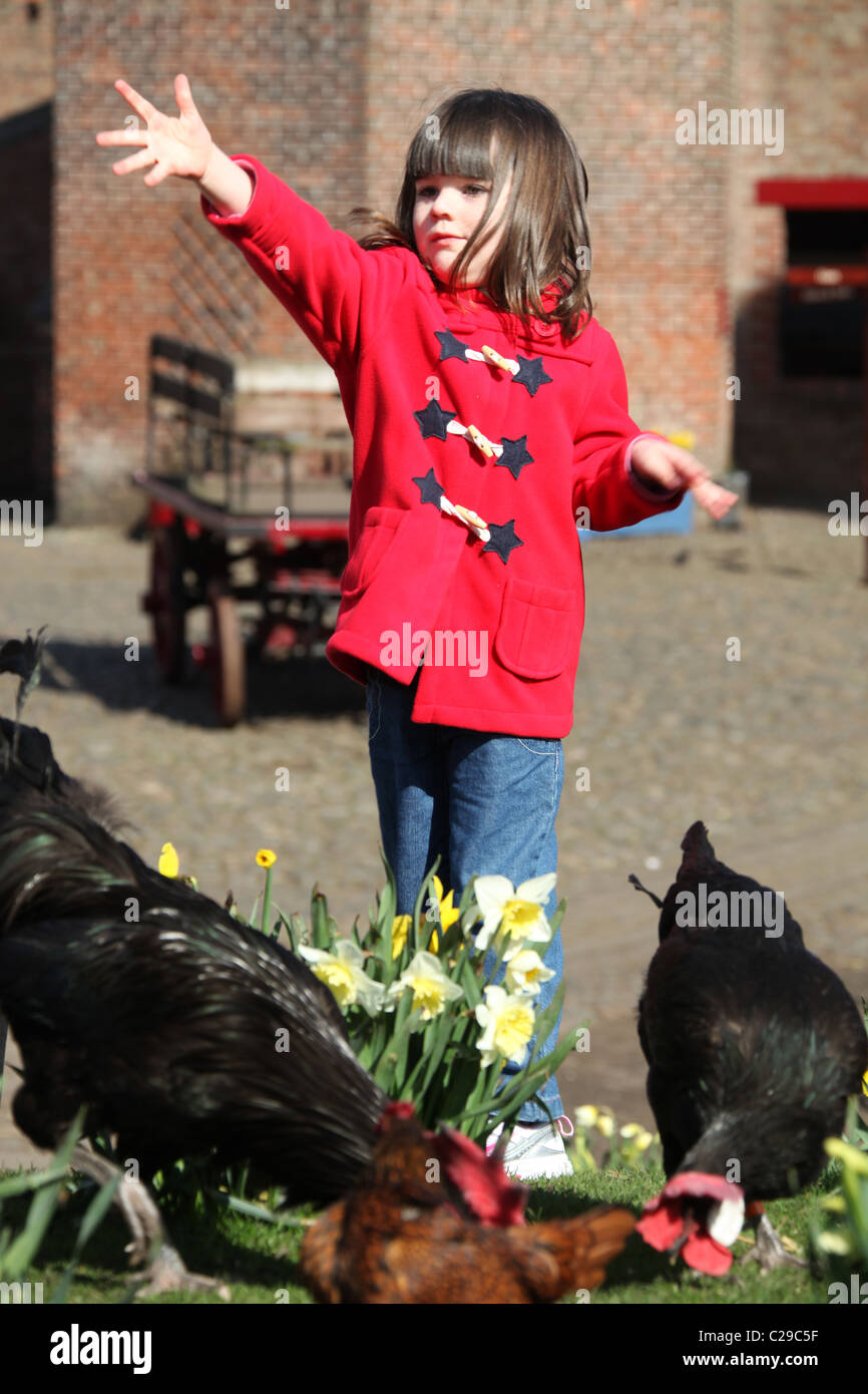 Estate of Tatton Park, England. A pretty young girl in a bright red ...