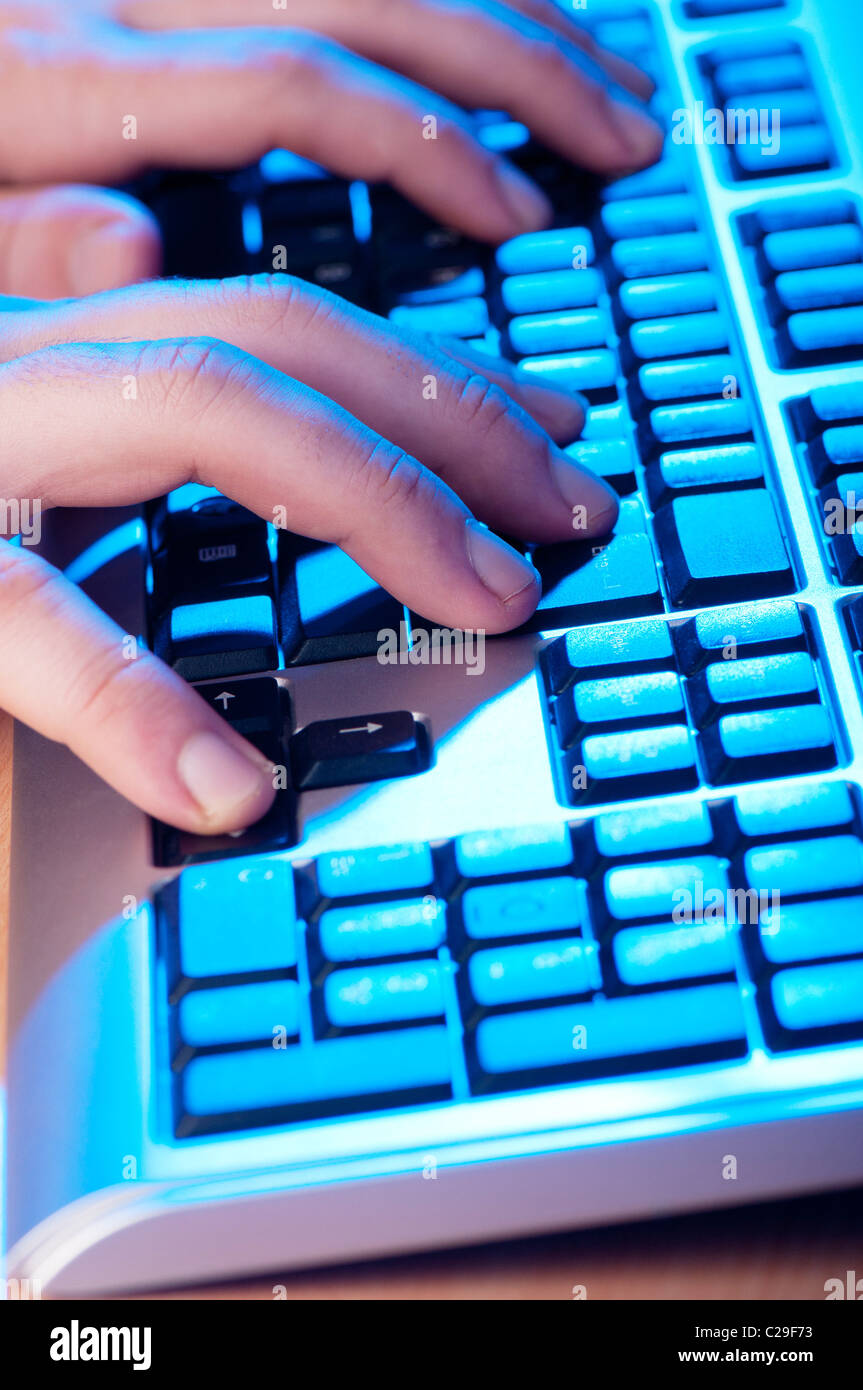 Two hands working on the silver keyboard Stock Photo - Alamy