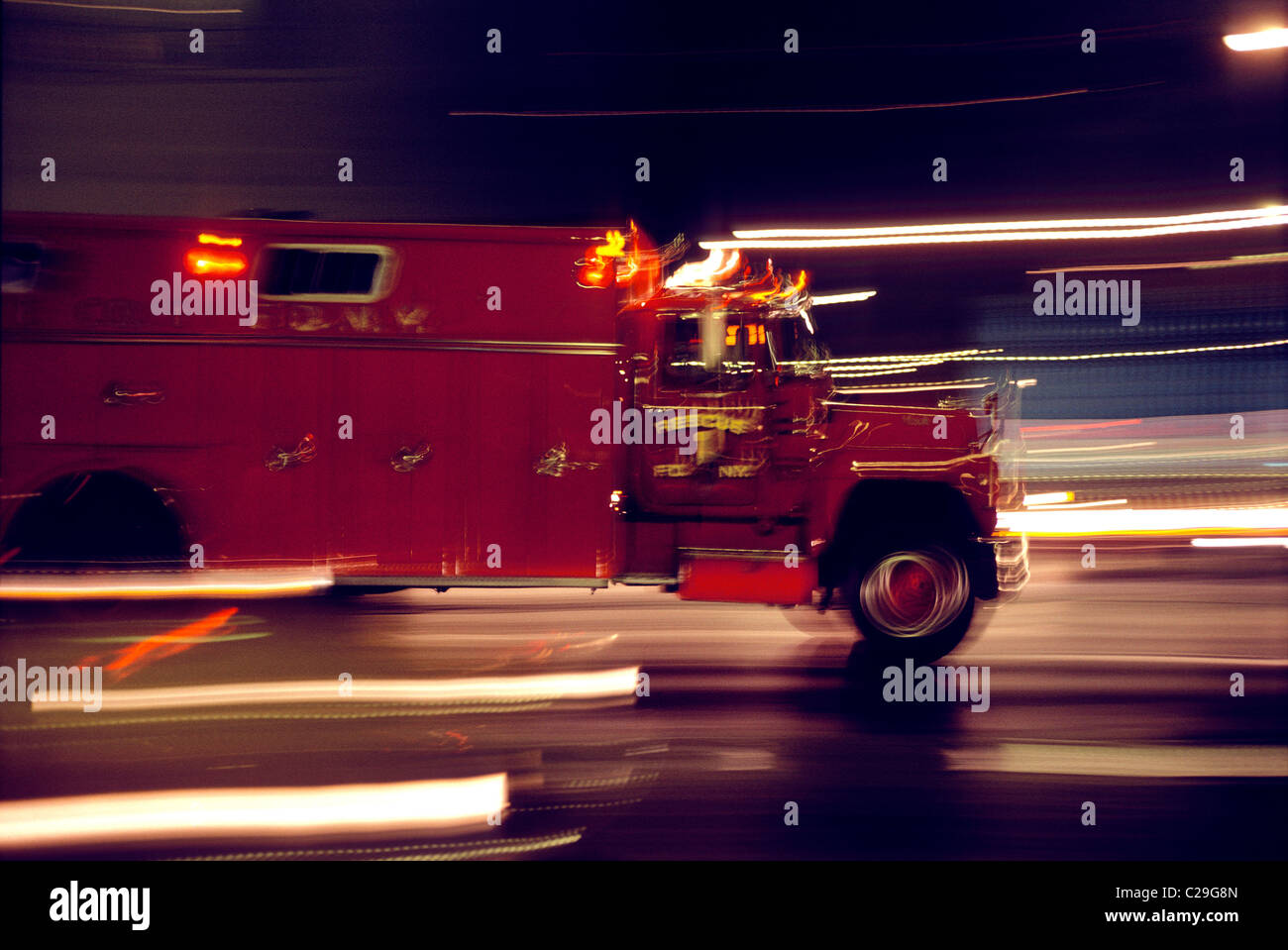 Blurred motion view of a fire truck racing to an emergency at night ...