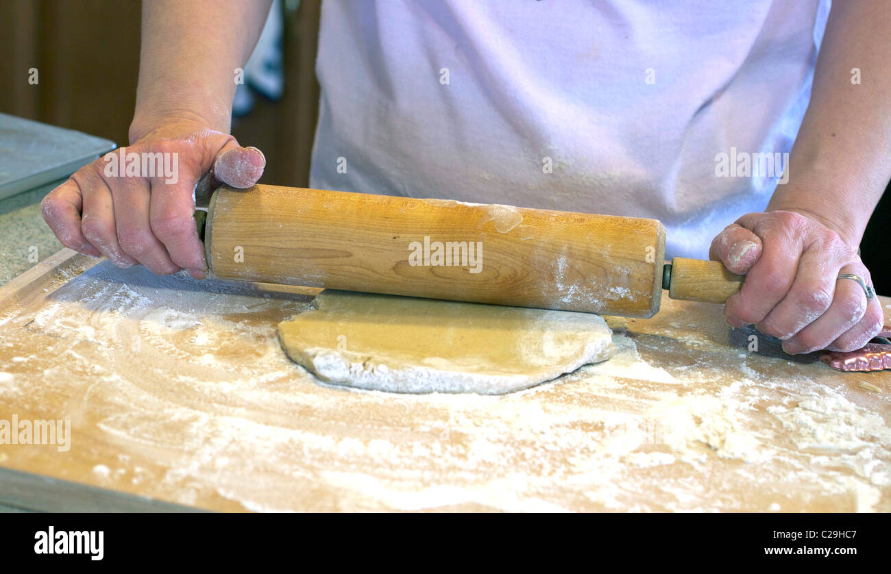 Baker using a rolling pin to roll out dough Stock Photo - Alamy