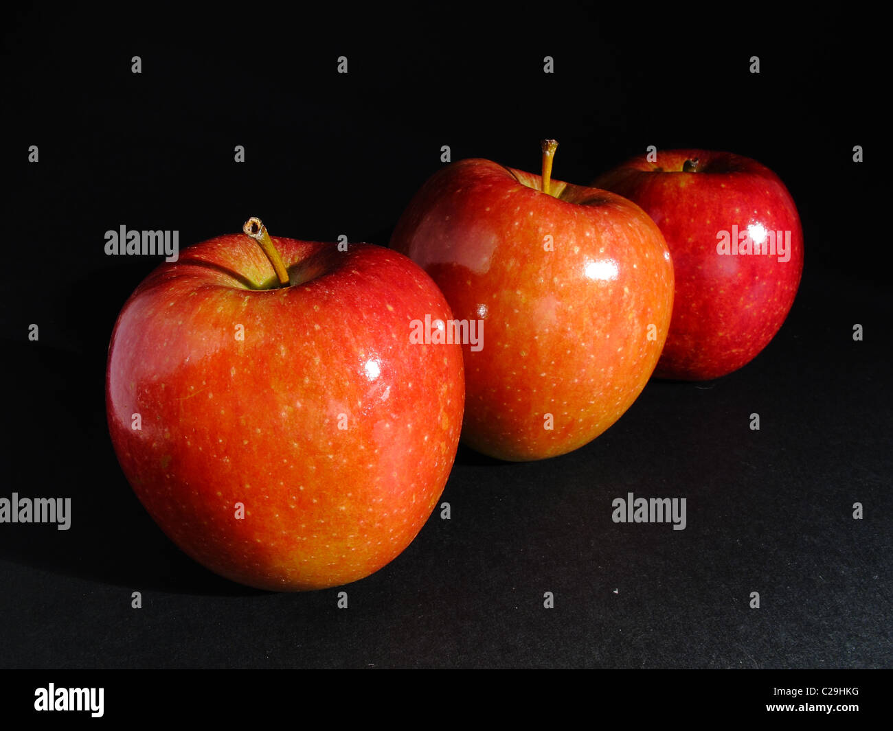 Three red apples bright in a row Stock Photo - Alamy