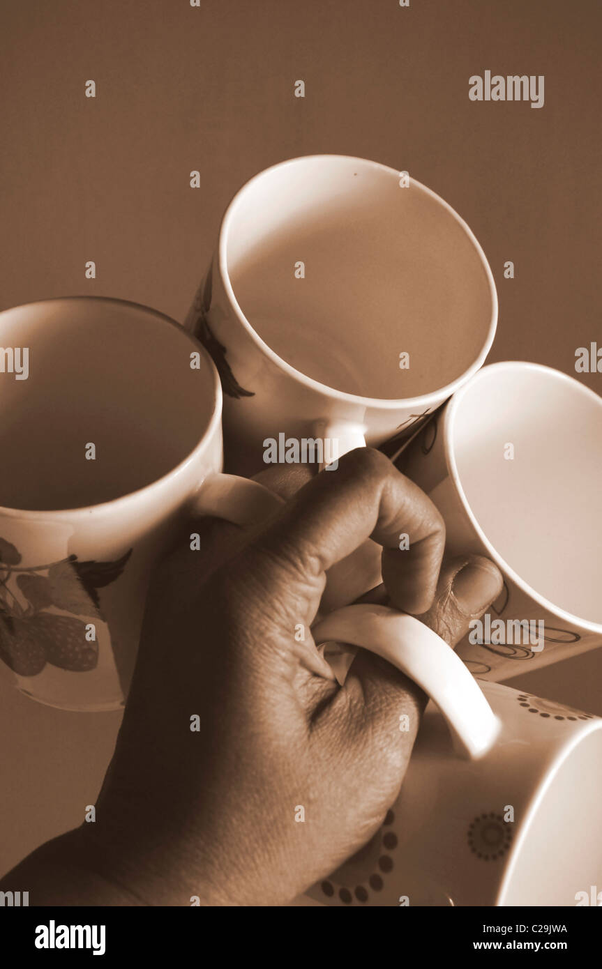 holding mugs in hand Stock Photo - Alamy
