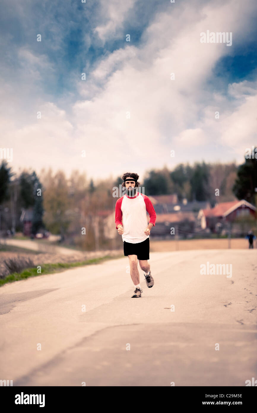 A runner with long hair and beard jogging in the country - Retro style ...