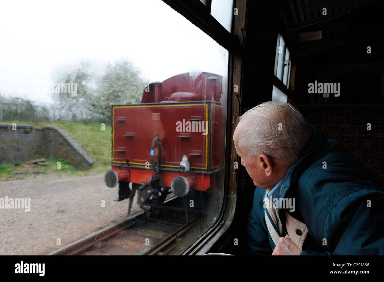 pensioner looking out of train window at passing steam train great ...