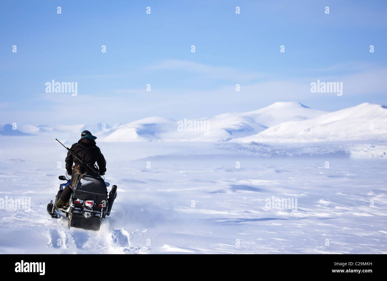 A winter landscape with a snowmobile travelling across frozen ice Stock ...