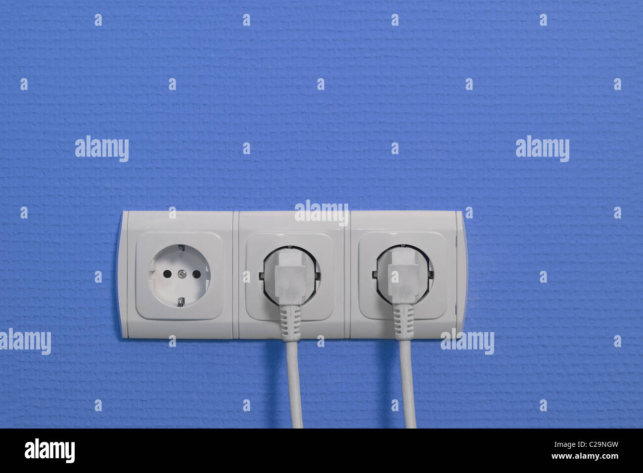 Electric outlets on blue wall with connected cables Stock Photo - Alamy