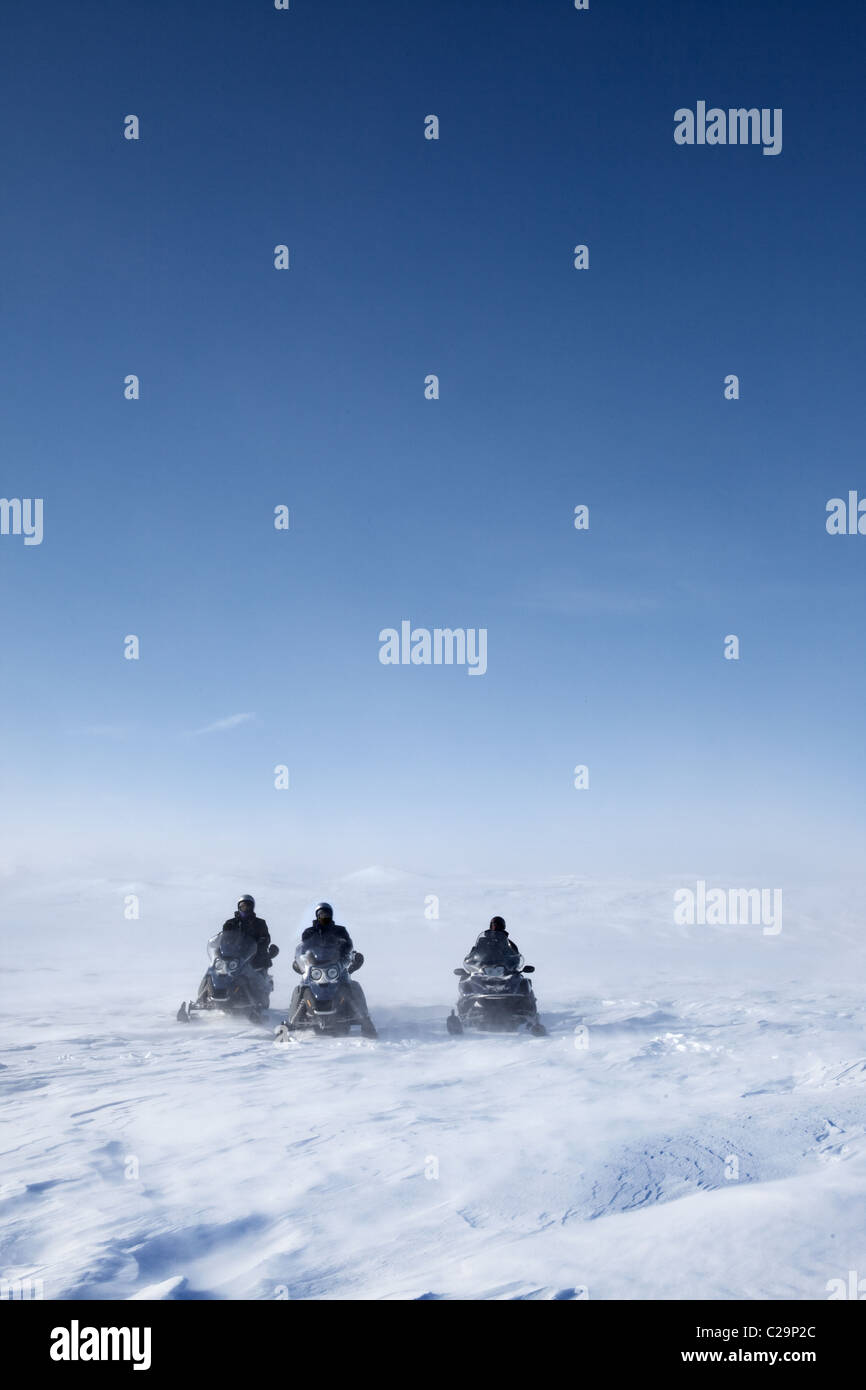 Three snowmobiles on a winter landscape with blowing snow Stock Photo ...