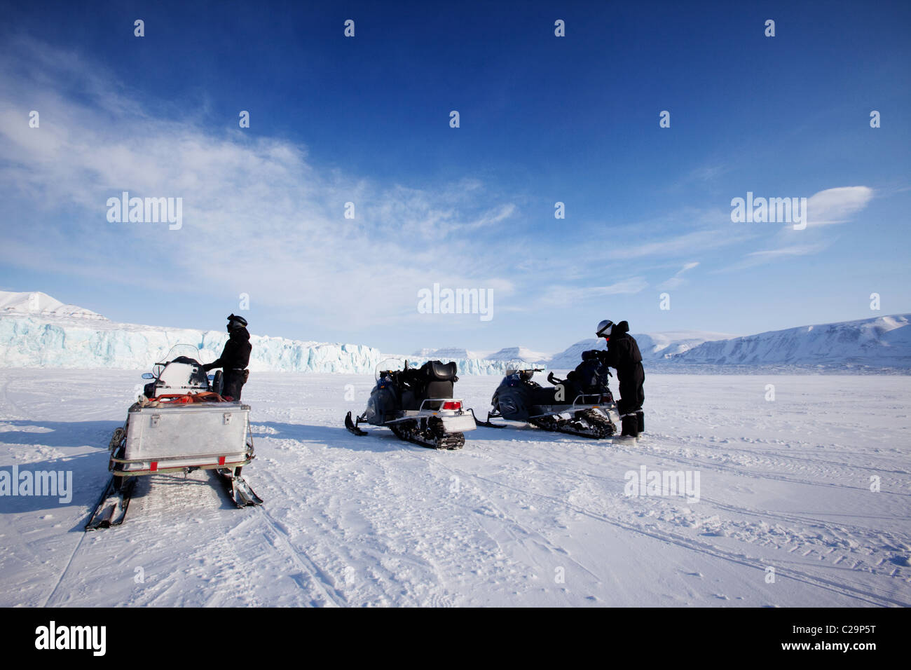 Three snowmobiles in front of a glacier, Svalbard, Norway Stock Photo ...