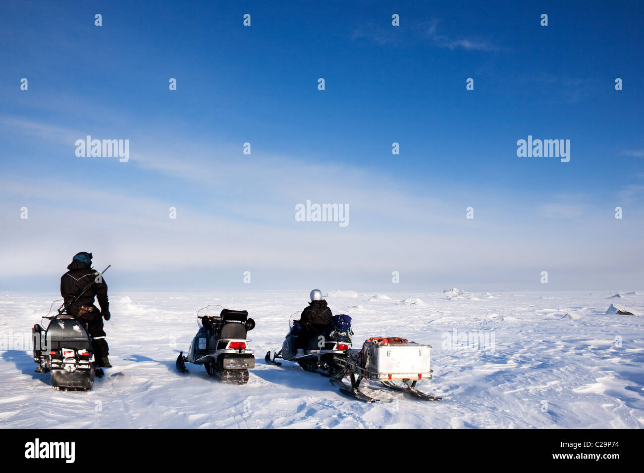 Three snowmobiles on a svalbard landscape of barren snow Stock Photo ...