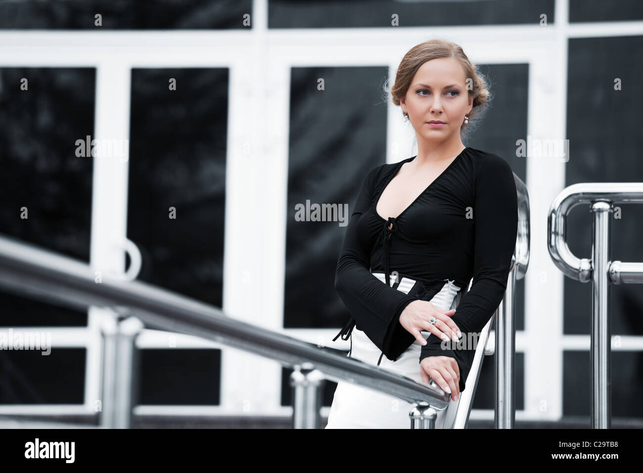 Beautiful young woman leaning on the handrail Stock Photo - Alamy