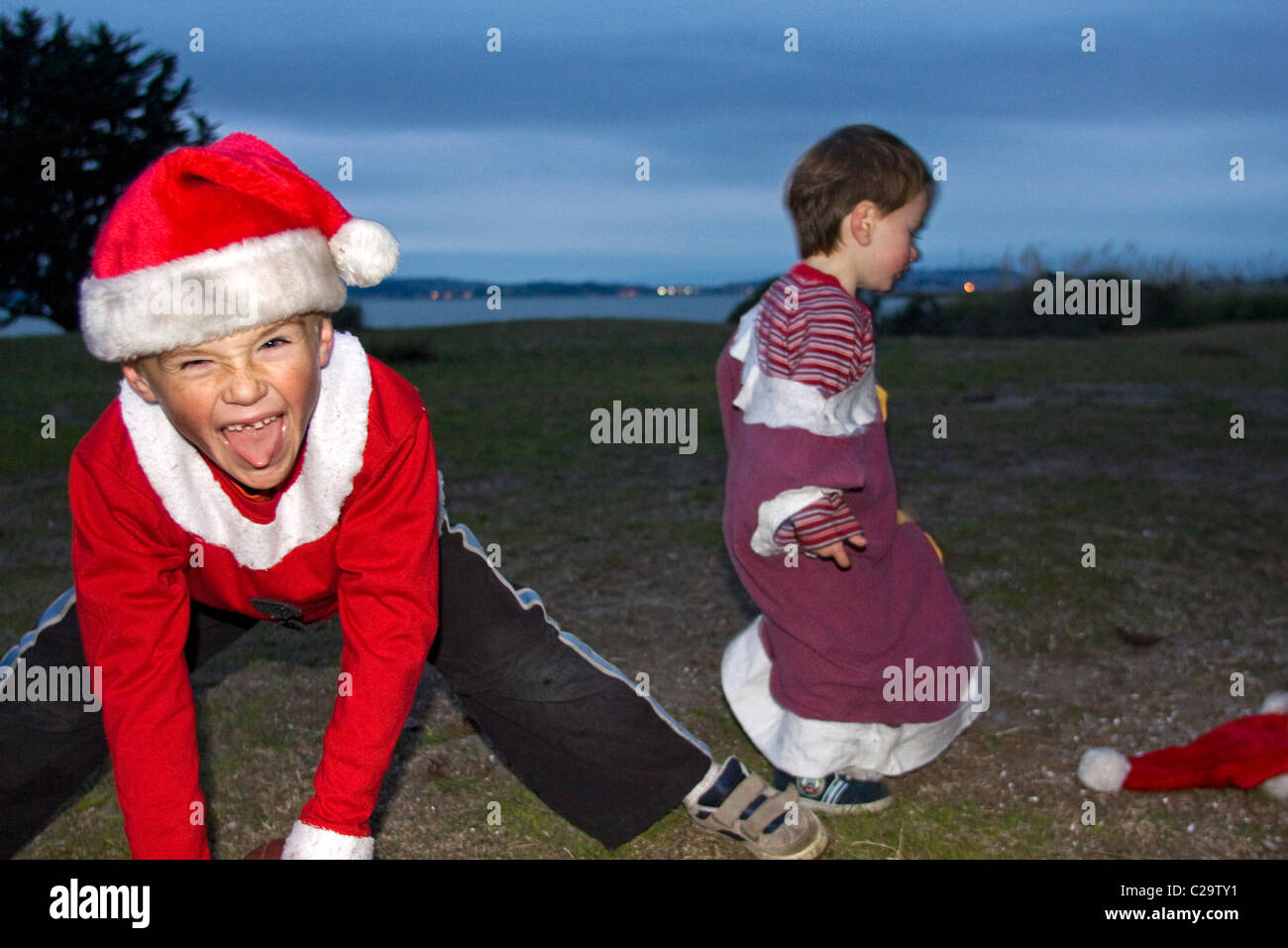 A seven year old boy having fun playing Santa Claus during Christmas ...
