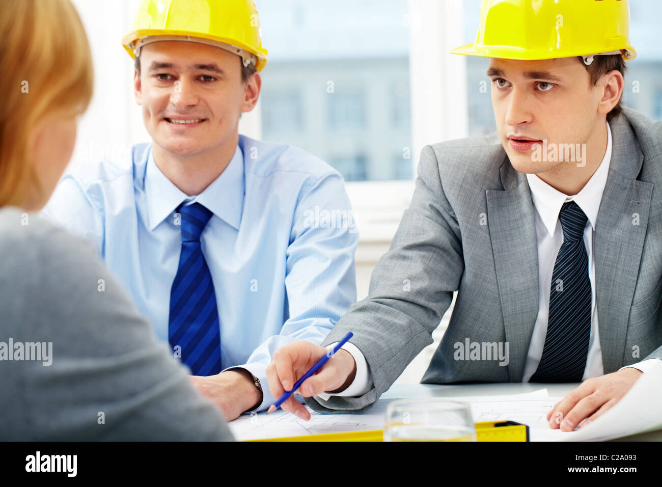 Two architects talking to their colleagues Stock Photo - Alamy