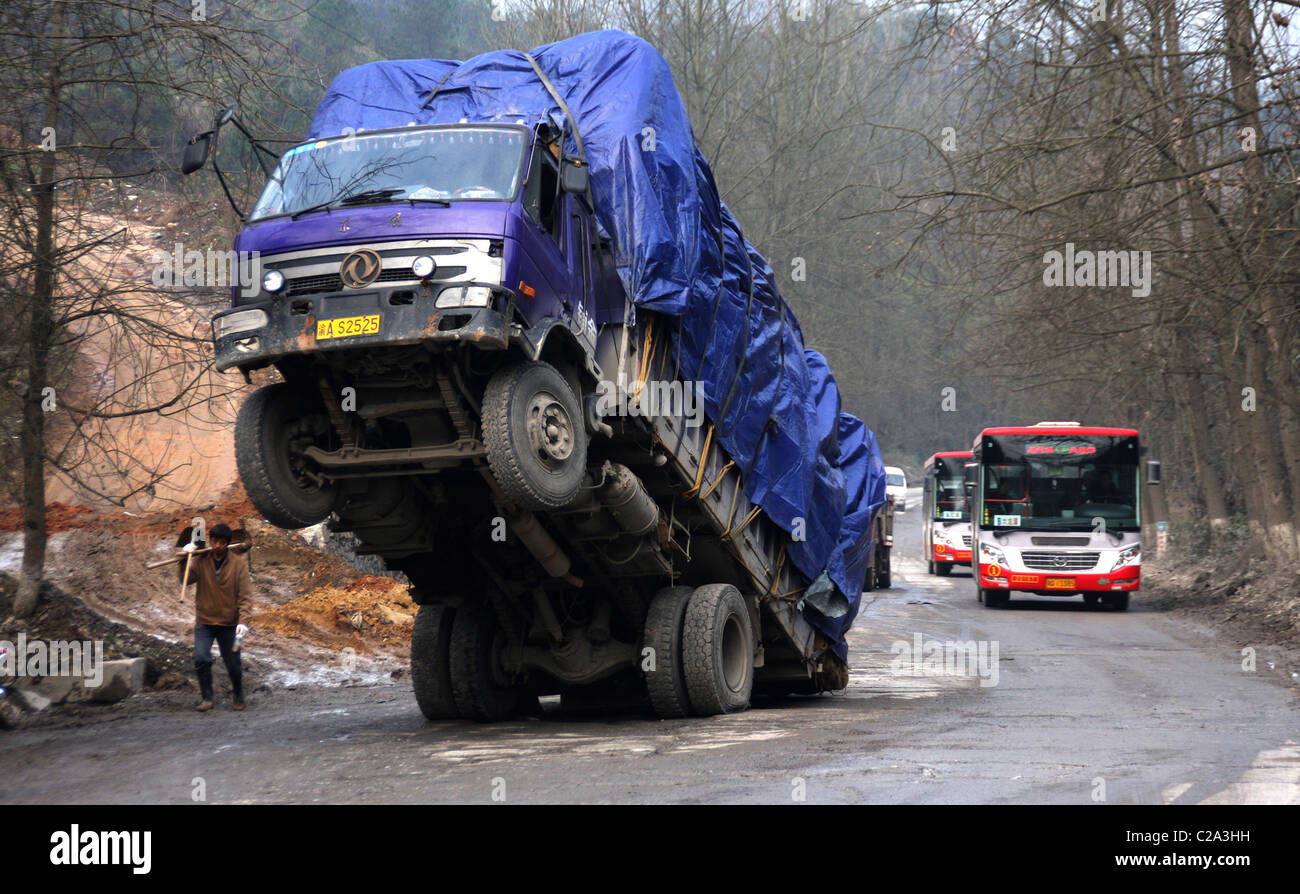 A truck carrying a heavy load loses balances and tips over in China ...