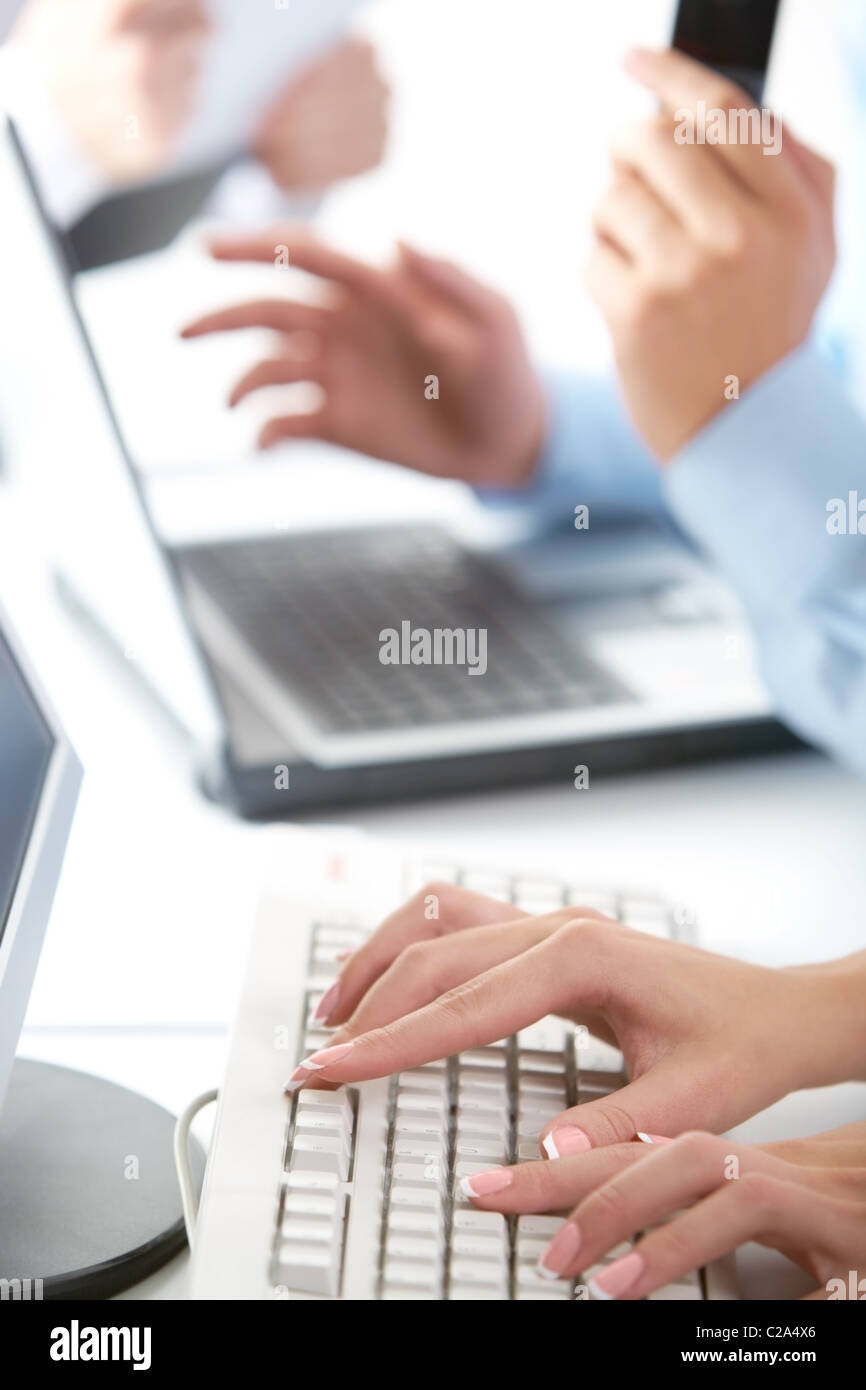 Typing female hands in office background Stock Photo - Alamy