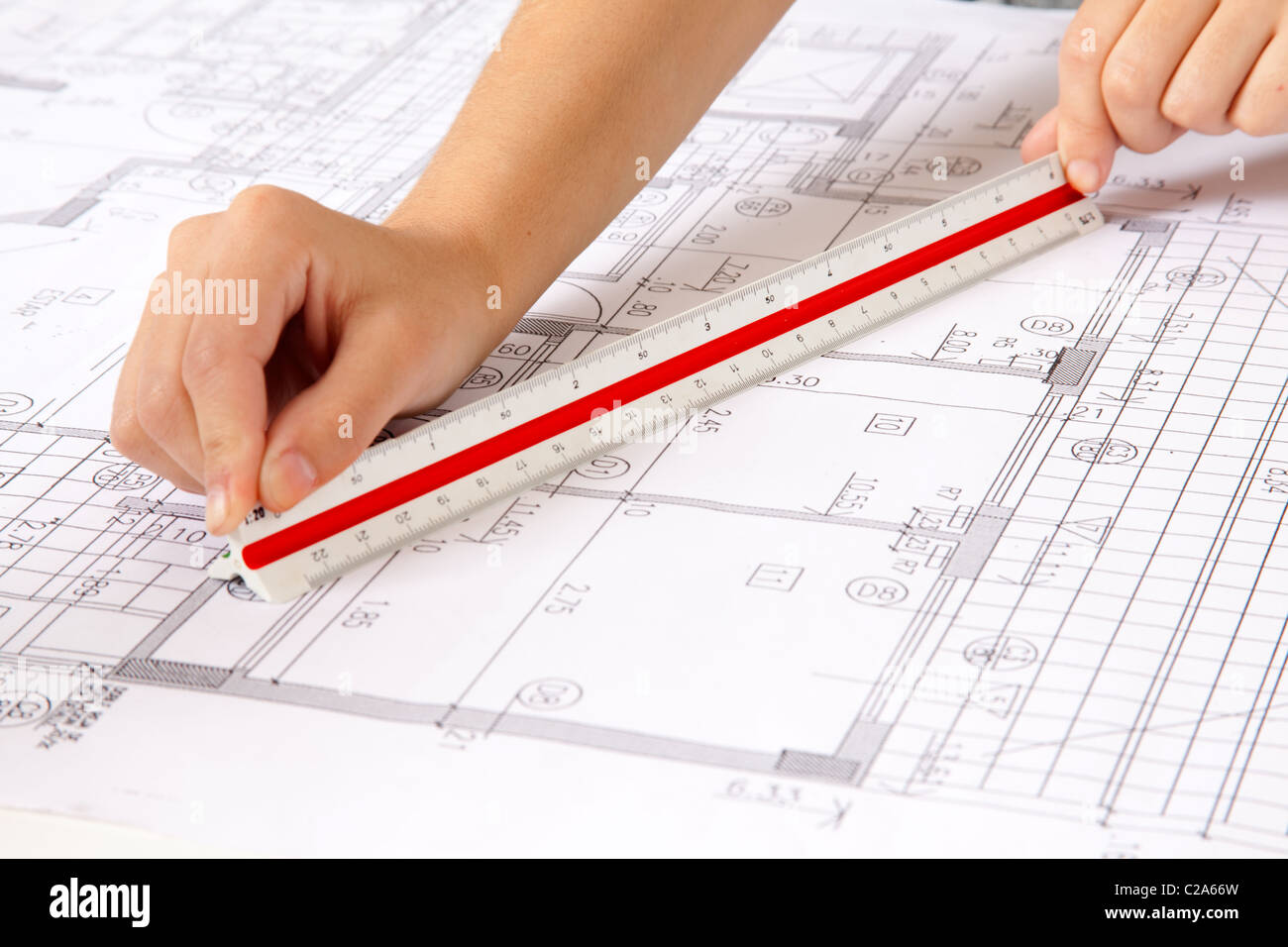 Two hands using a scale ruler on a set of blueprints Stock Photo - Alamy